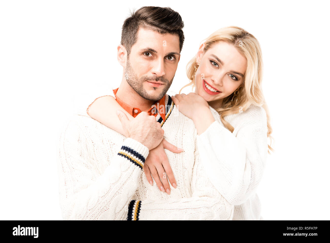 Attractive couple looking at camera while hugging and holding hands ...