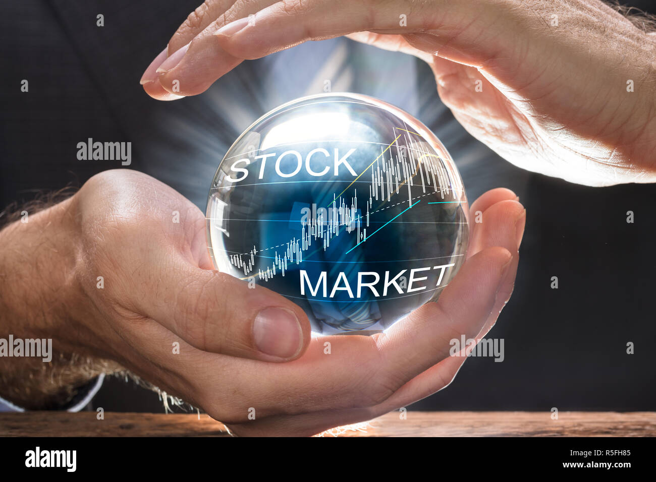 Businessman Covering Crystal Ball With Stock Market Graphs Stock Photo ...