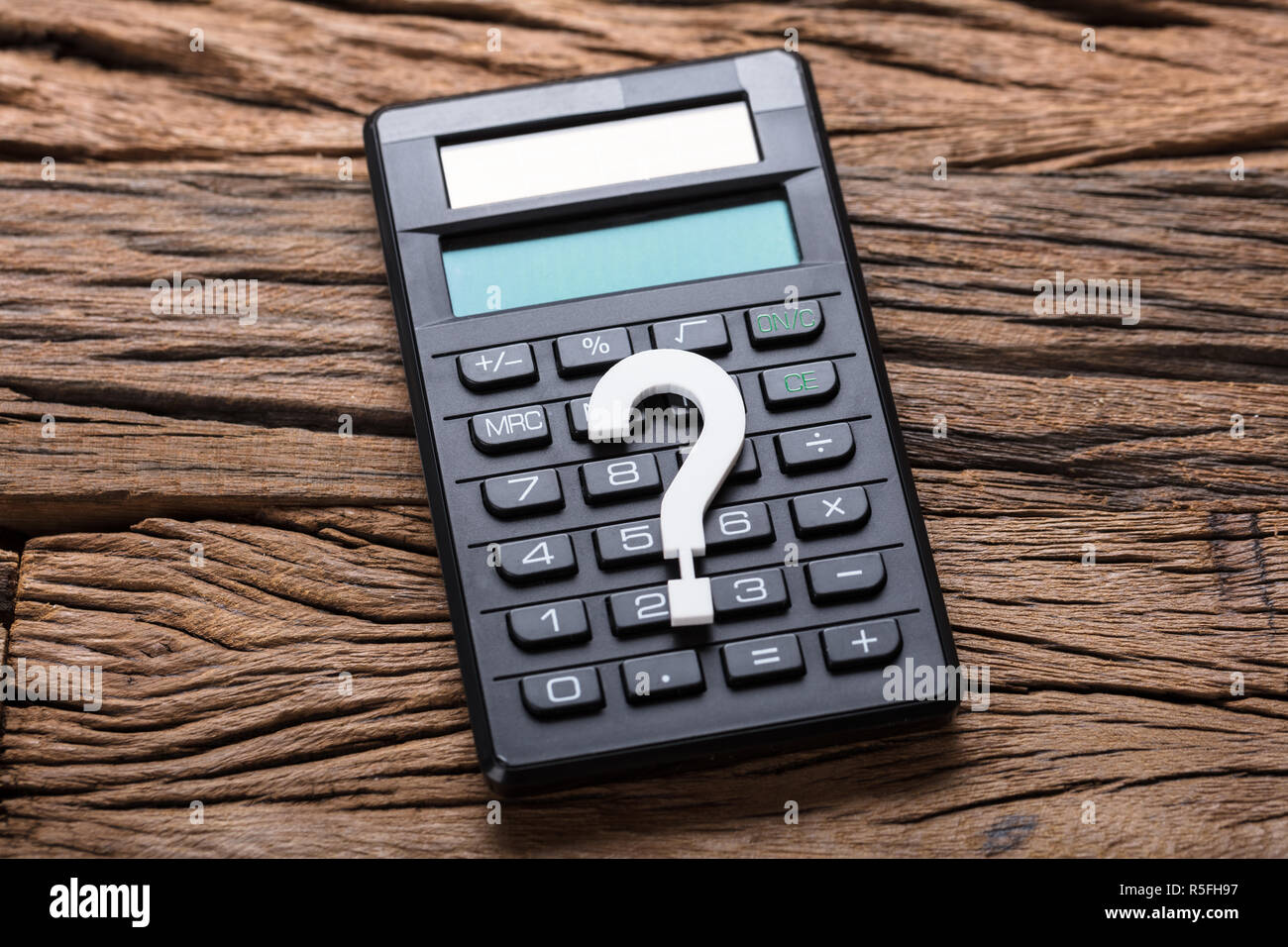 Closeup Of Question Mark And Calculator On Wood Stock Photo - Alamy