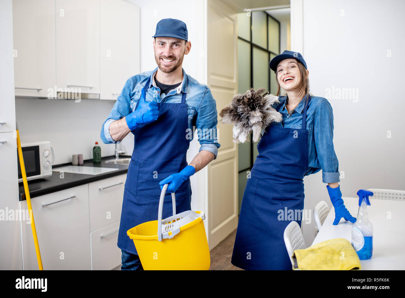 Portrait of a couple as a professional cleaners in uniform standing ...