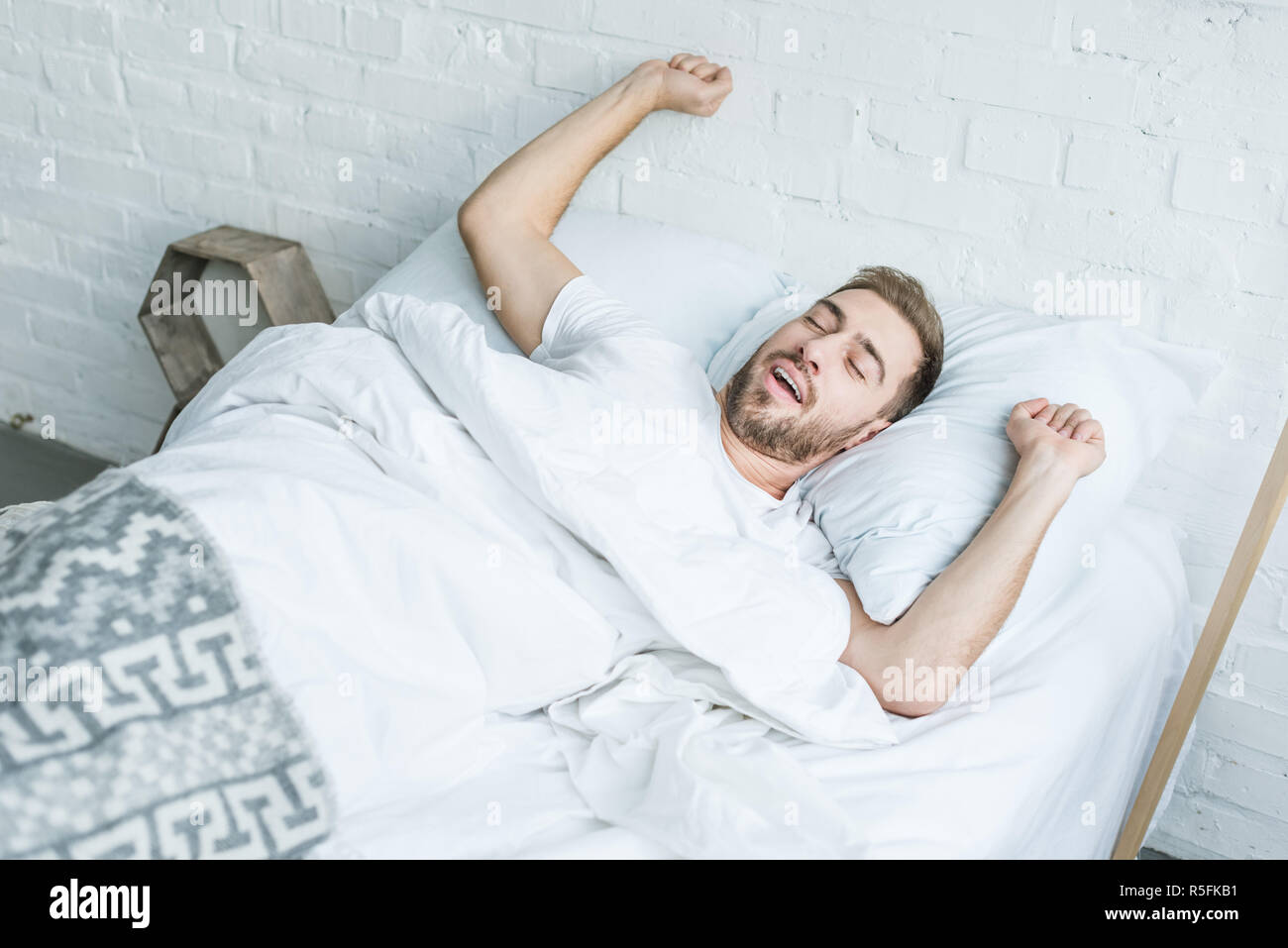 Young man yawning in bed hi-res stock photography and images - Alamy