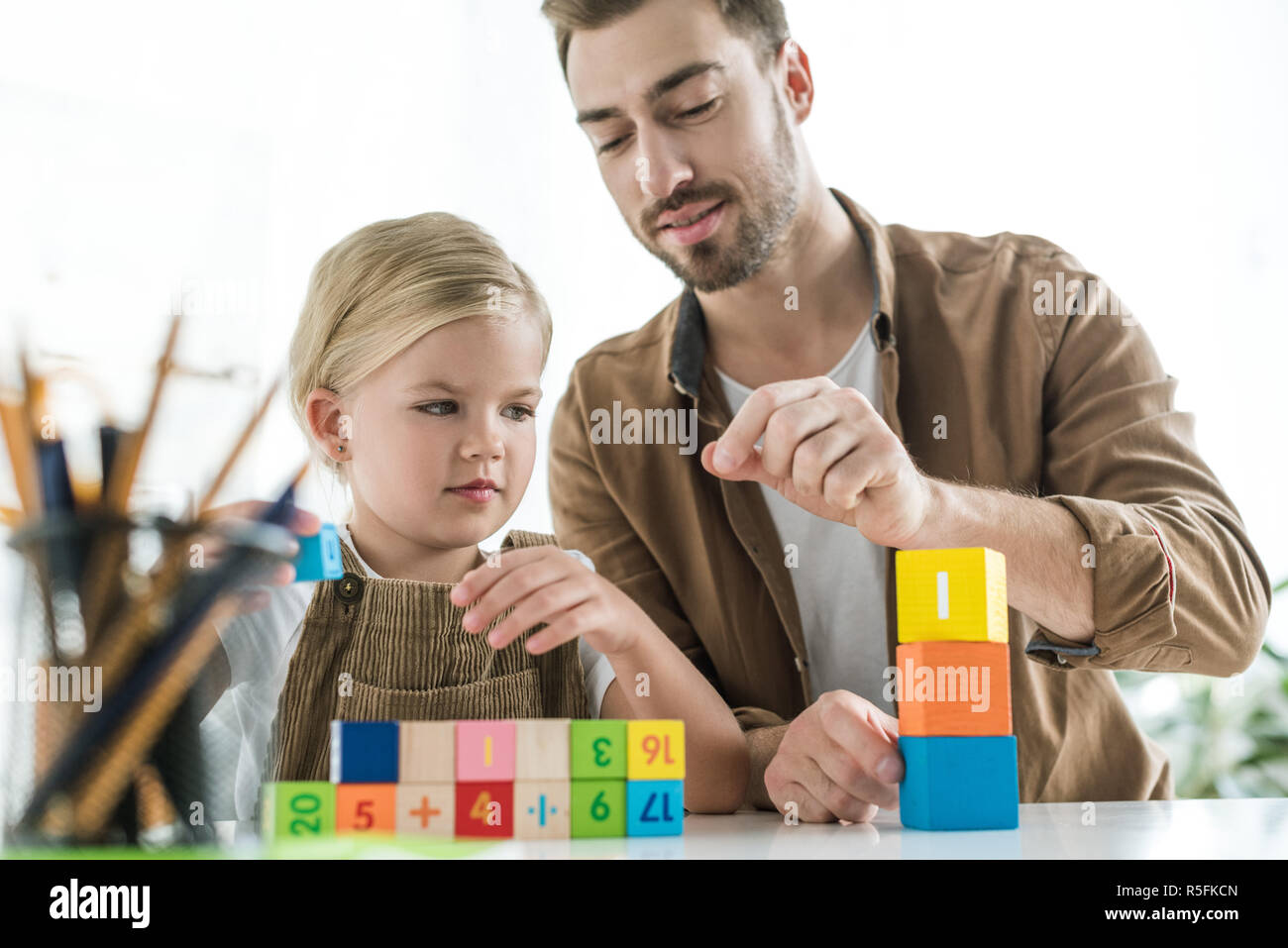 father explaining math to little daughter and playing with colorful ...