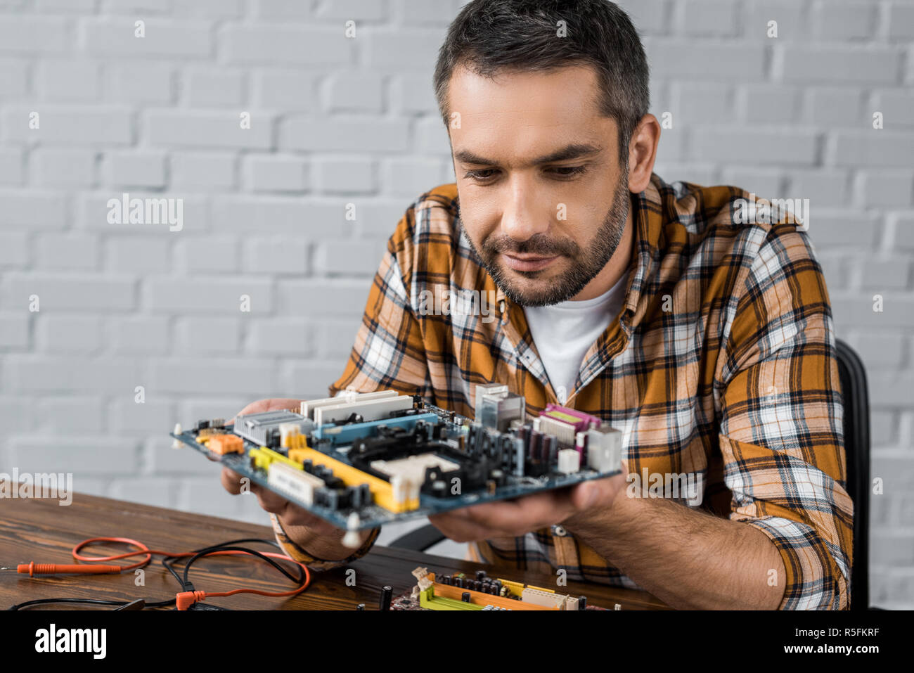 serious handsome computer engineer holding motherboard Stock Photo - Alamy