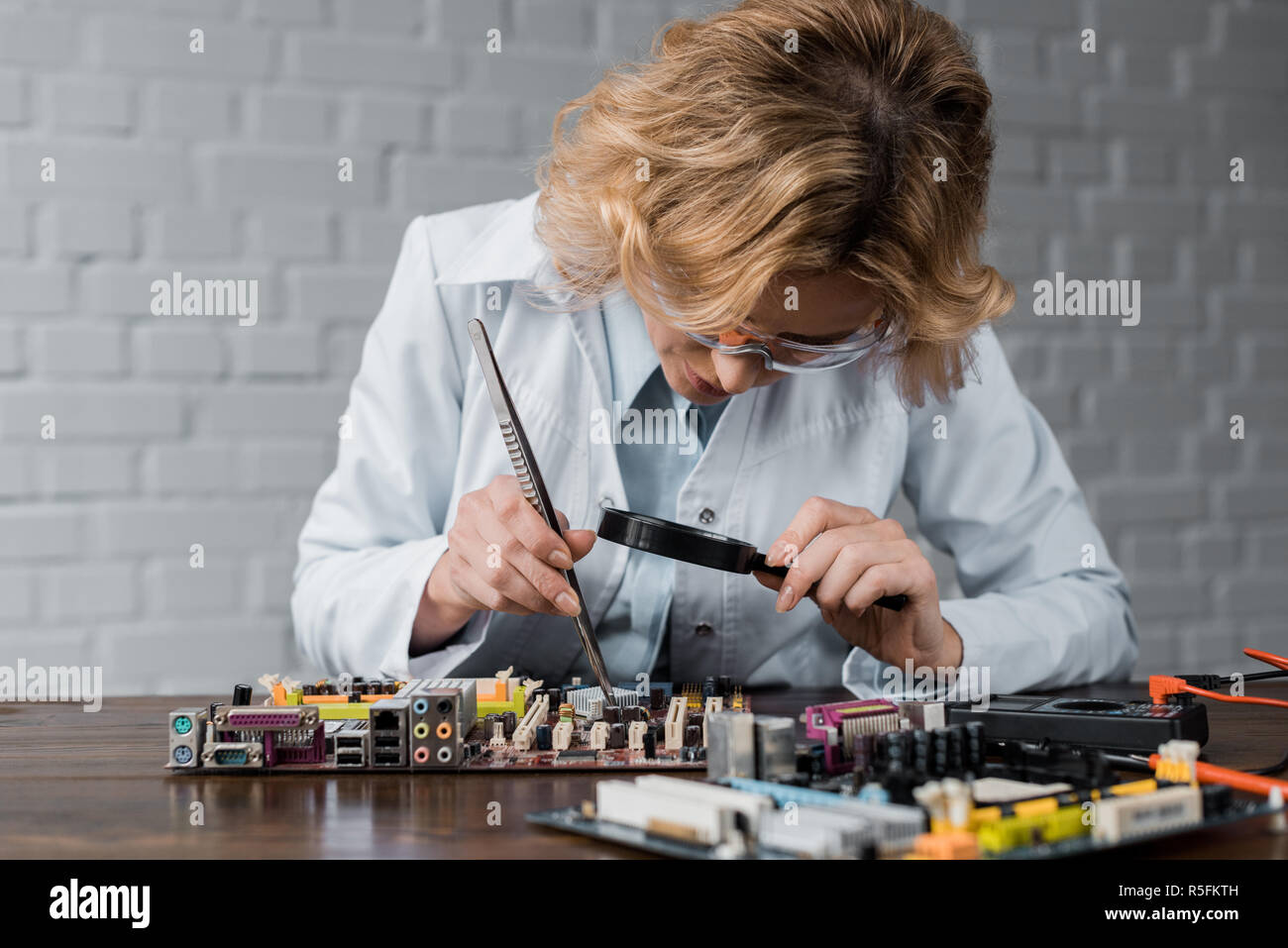 concentrated female computer engineer repairing motherboard Stock Photo ...