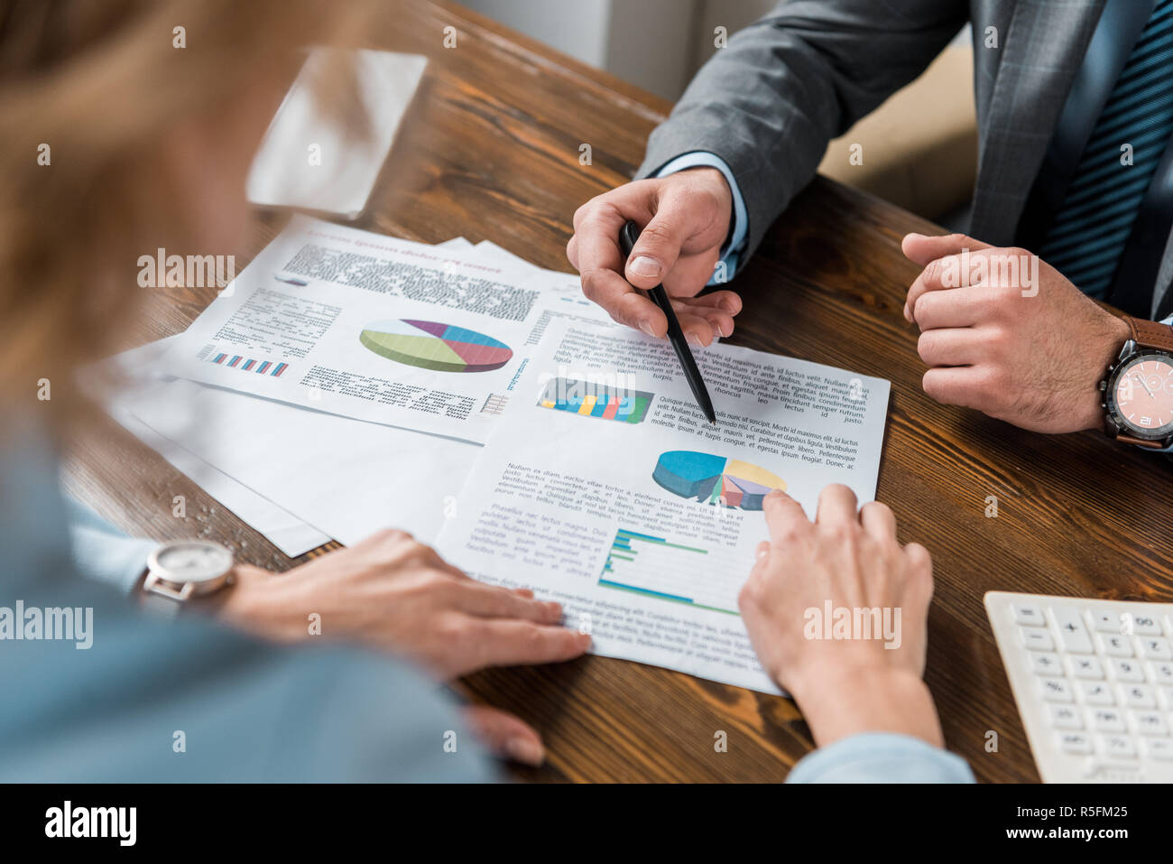 partial view of business people working with charts and graphs in ...