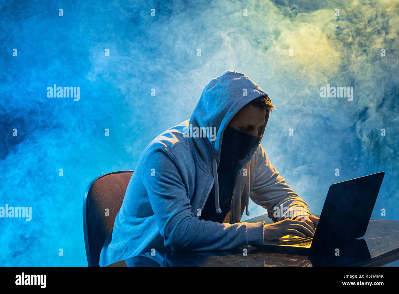 Hooded computer hacker stealing information with laptop Stock Photo - Alamy