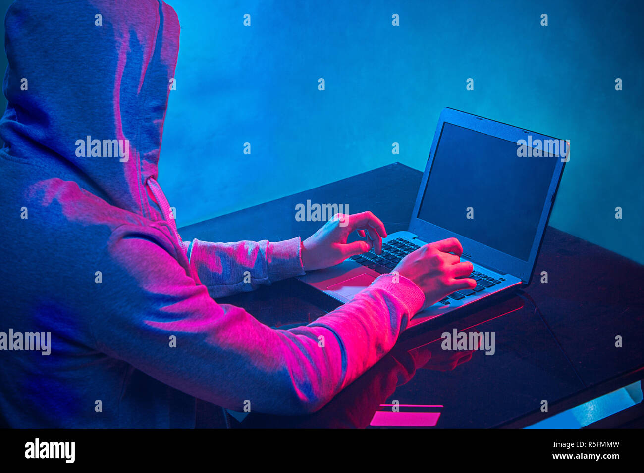 Hooded computer hacker stealing information with laptop Stock Photo - Alamy