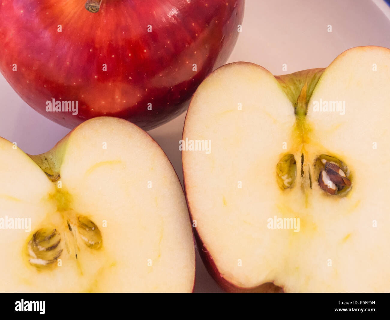 Apple cut in half with seeds and pulp to show Stock Photo - Alamy