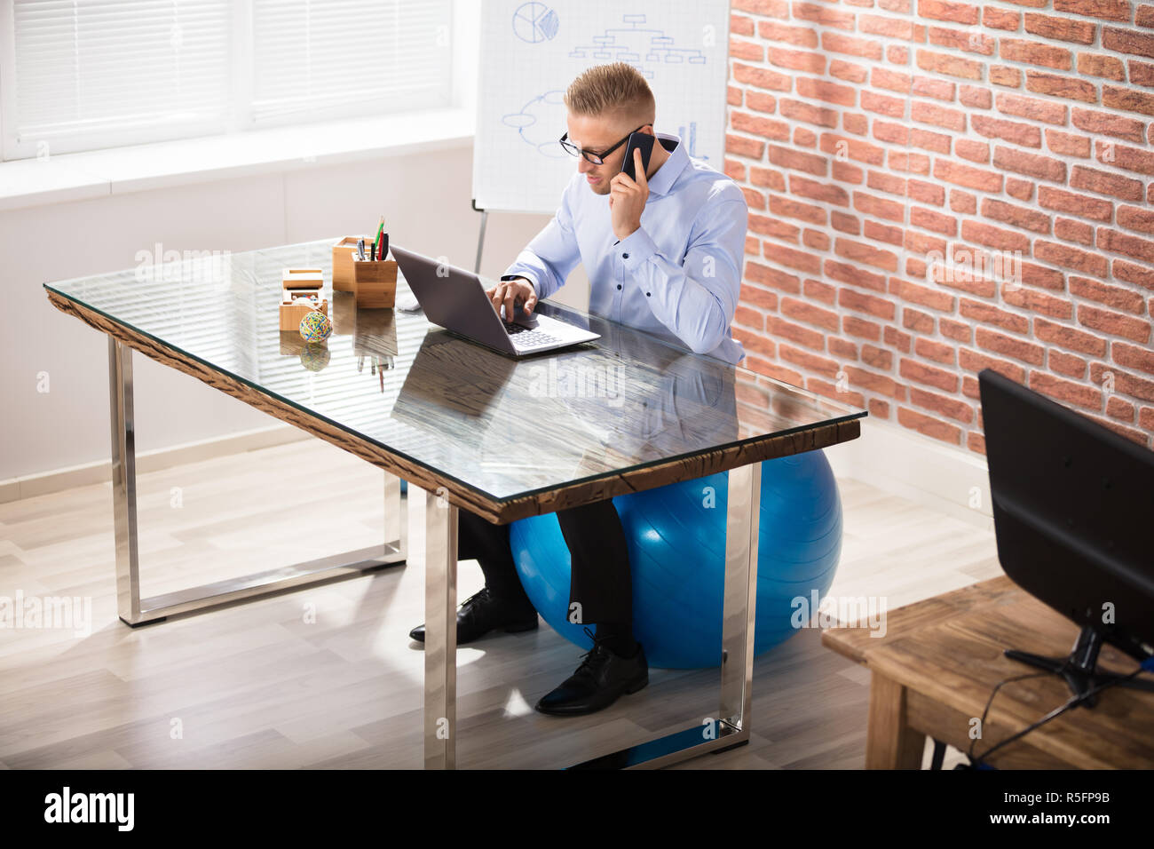 Man sitting on exercise ball, office hi-res stock photography and ...