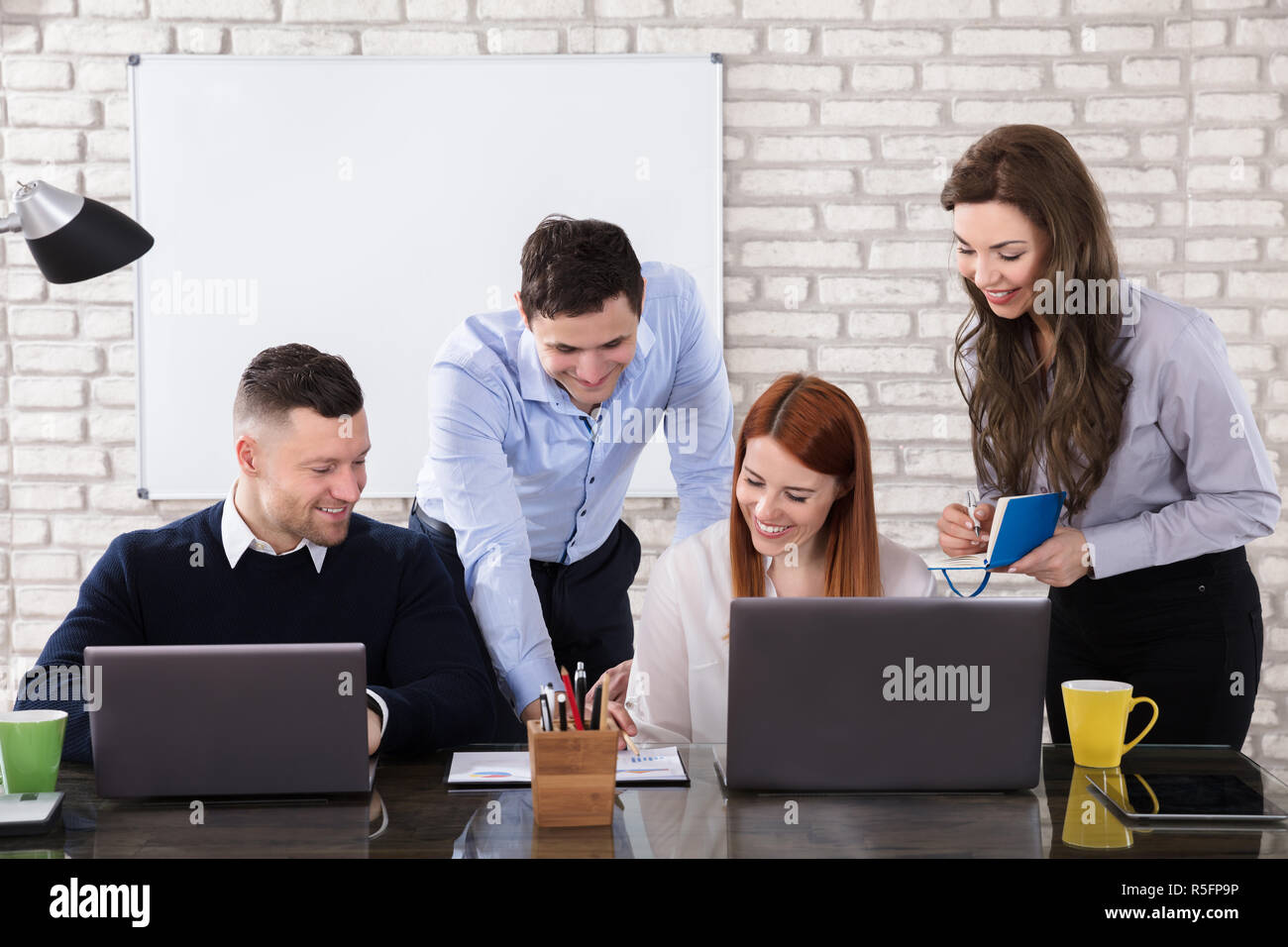 Happy Business People Doing Work At Workplace Stock Photo - Alamy