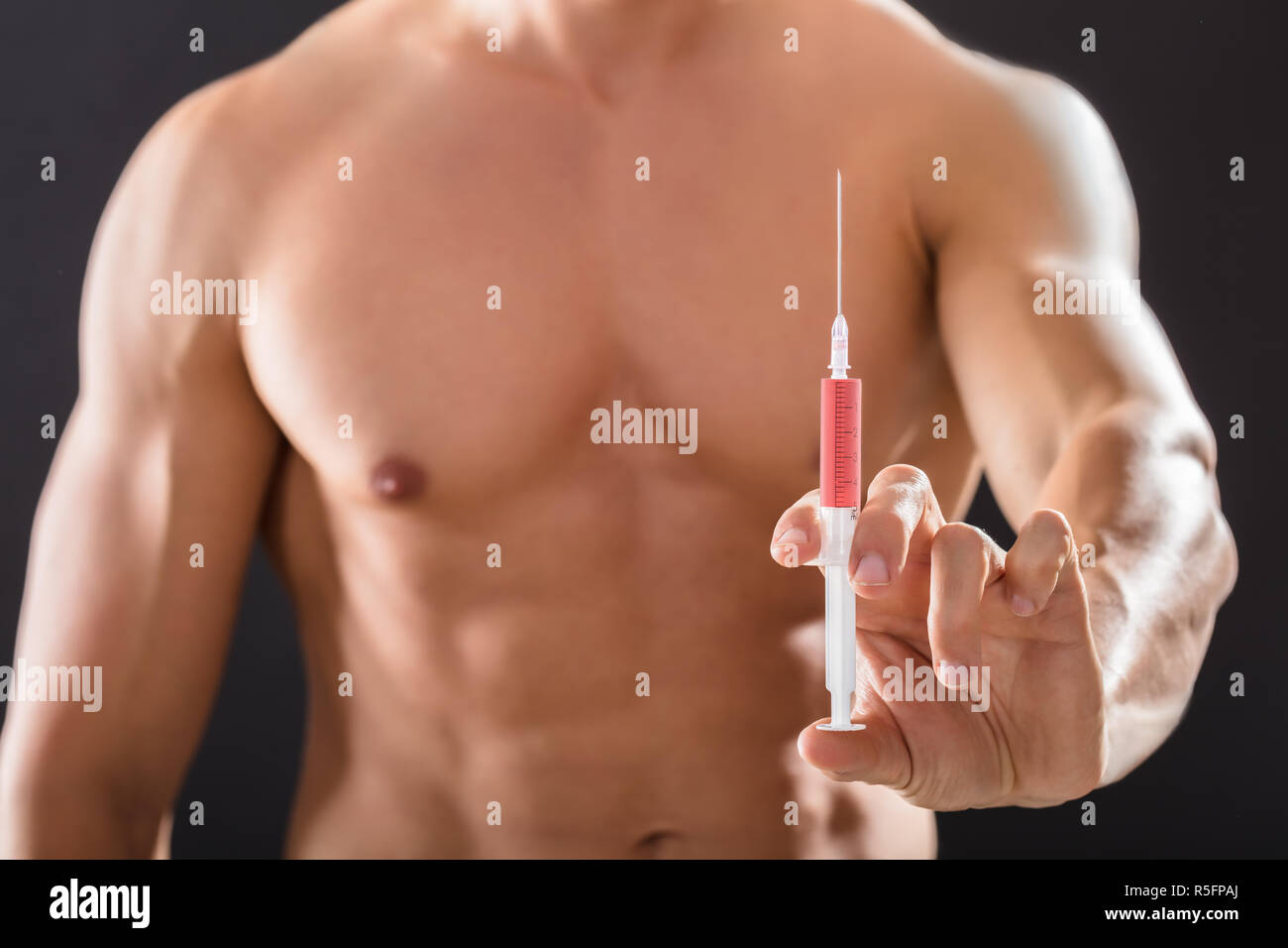 Shirtless Bodybuilder Man Holding Syringe In Hand Stock Photo - Alamy