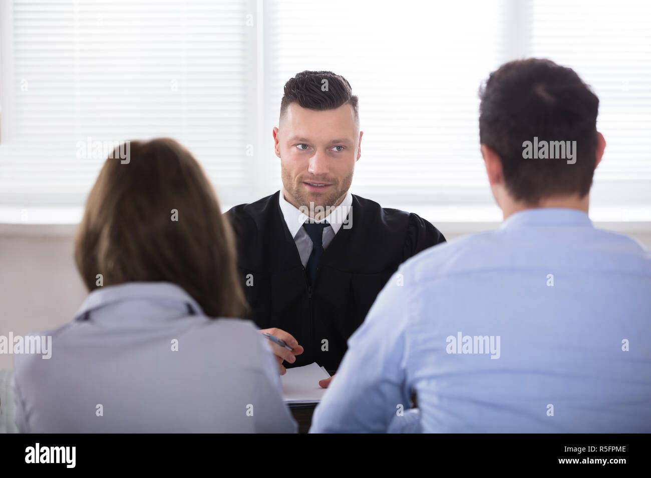Couple Sitting In Front Of Judge Stock Photo - Alamy
