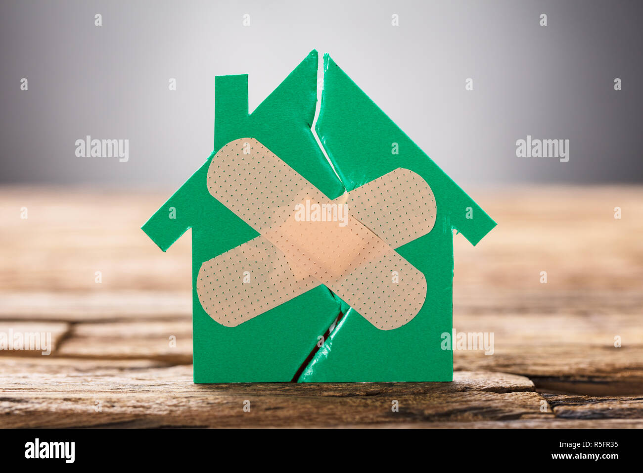 Closeup Of Broken House With Crossed Band Aid Stock Photo - Alamy