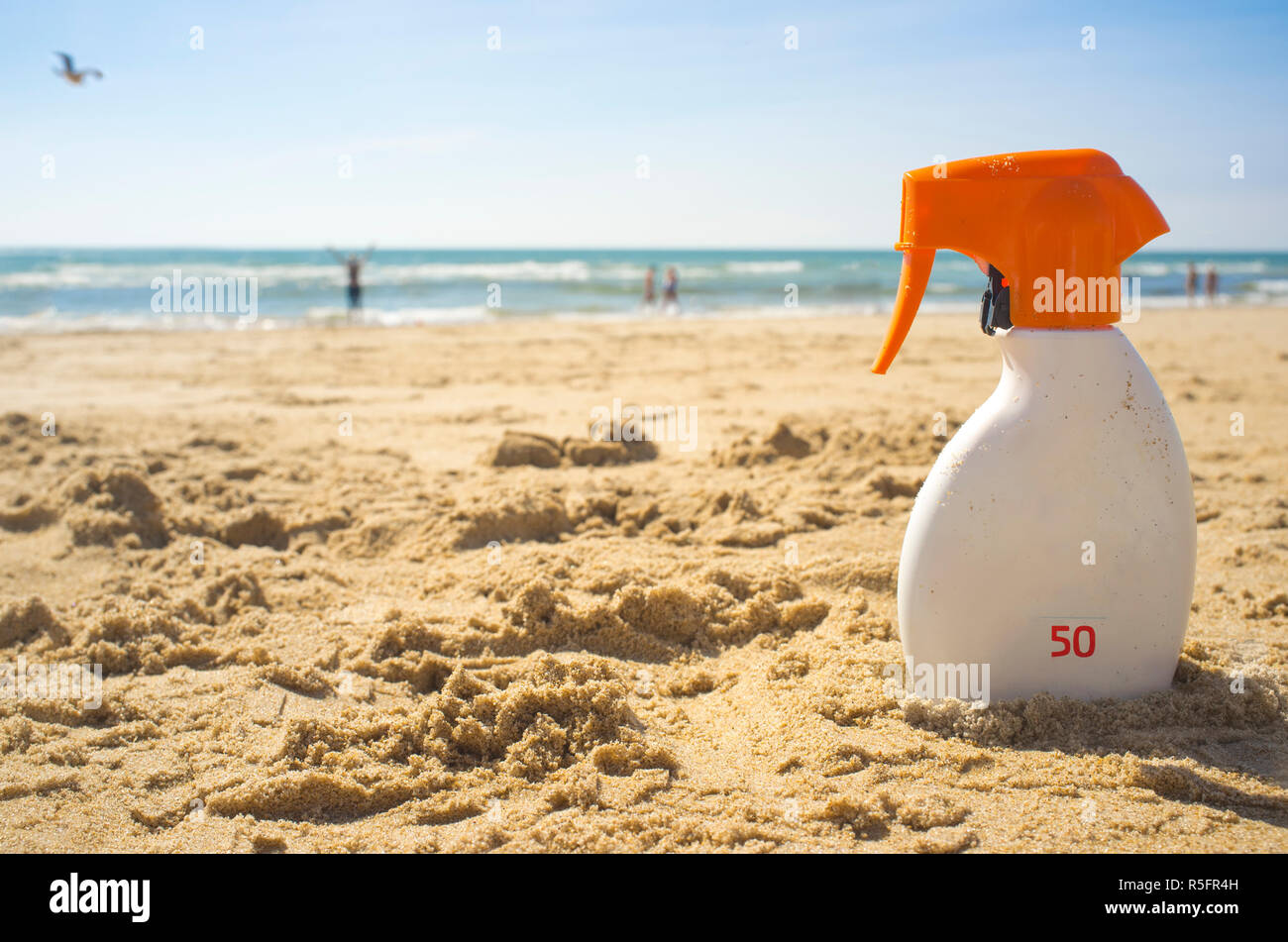 Sunblock cream with Sun Protection Factor or SPF 50 on beach sand ...