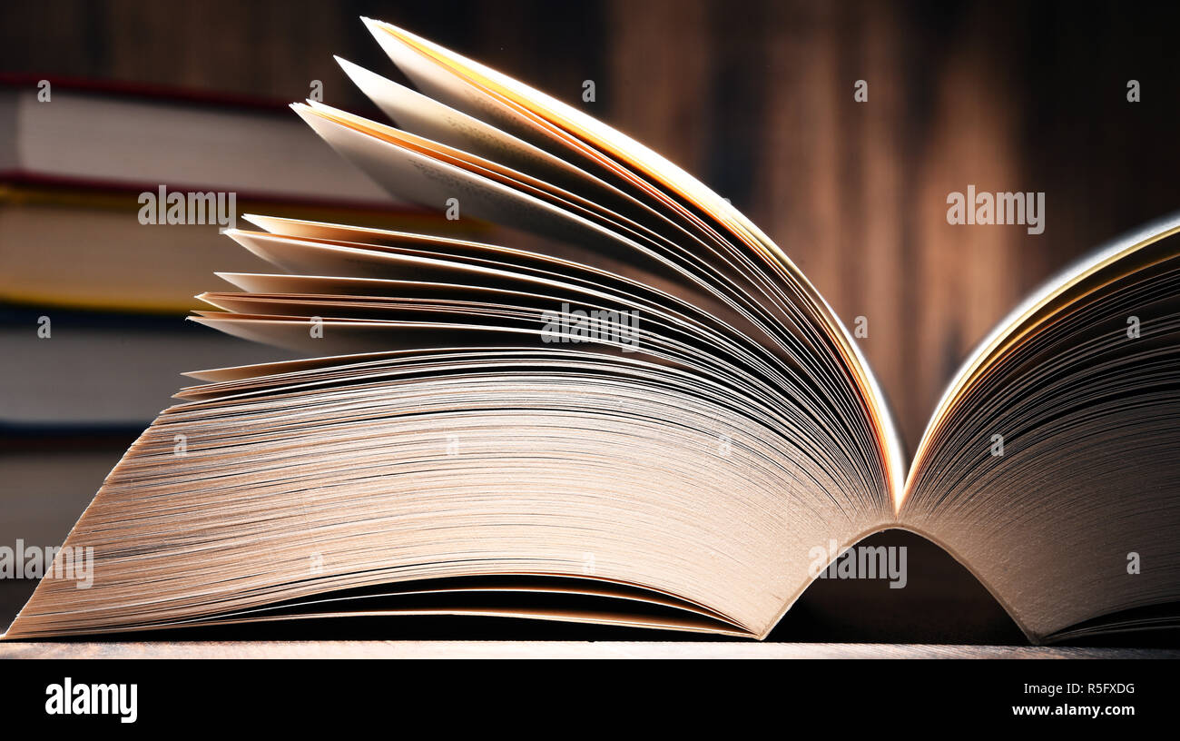 Composition with open book on the table Stock Photo - Alamy