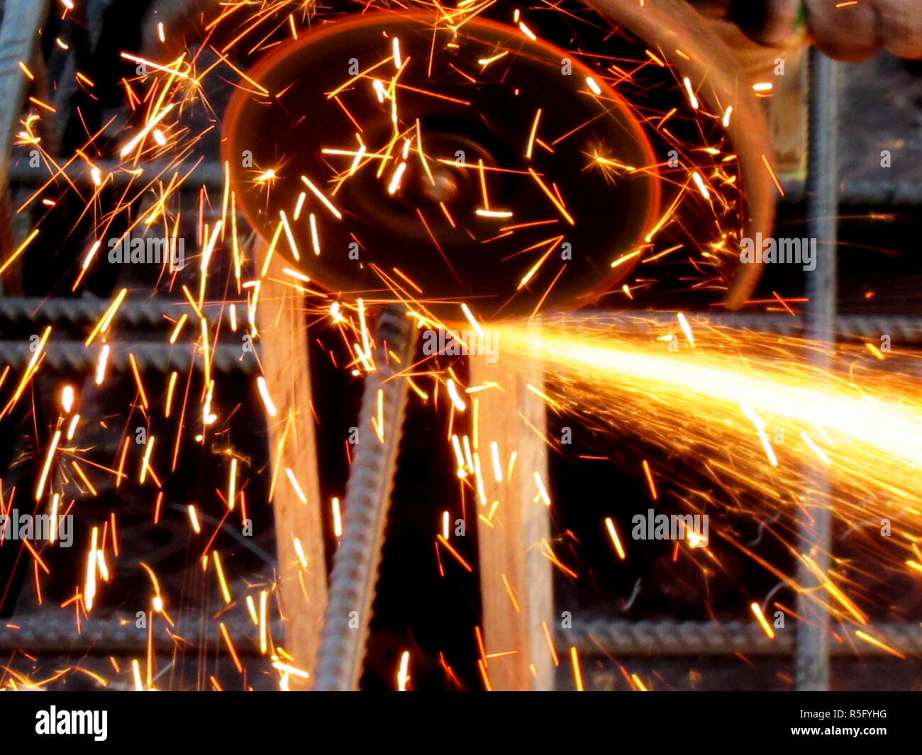Hot Sparks of fire from steel cutting machines when men are using the ...