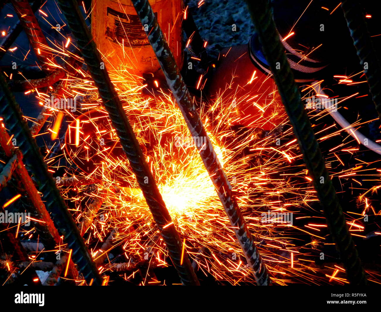 Hot Sparks of fire from steel cutting machines when men are using the ...