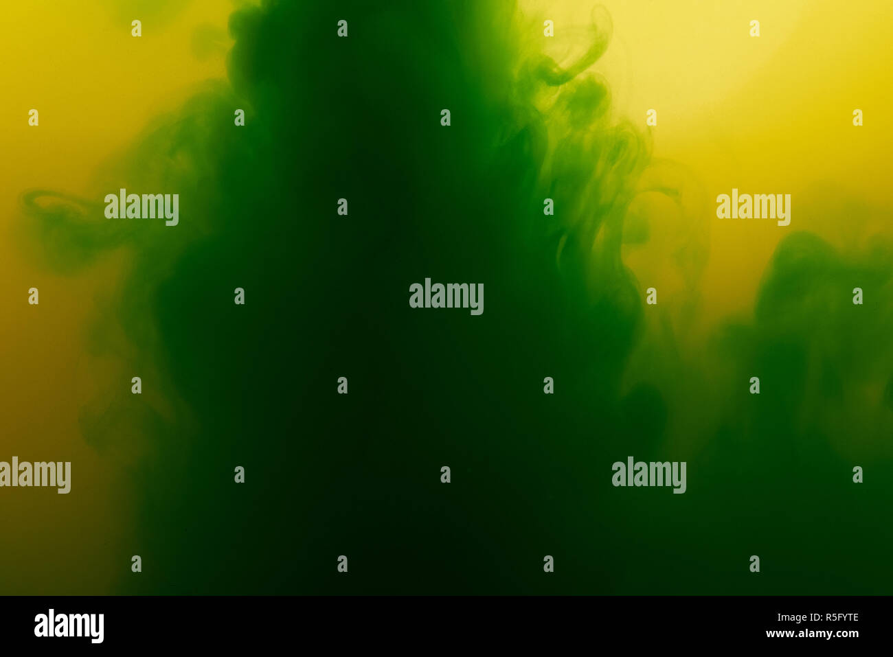 Green paint flow in yellow water. Mixed acrylic paint background Stock ...