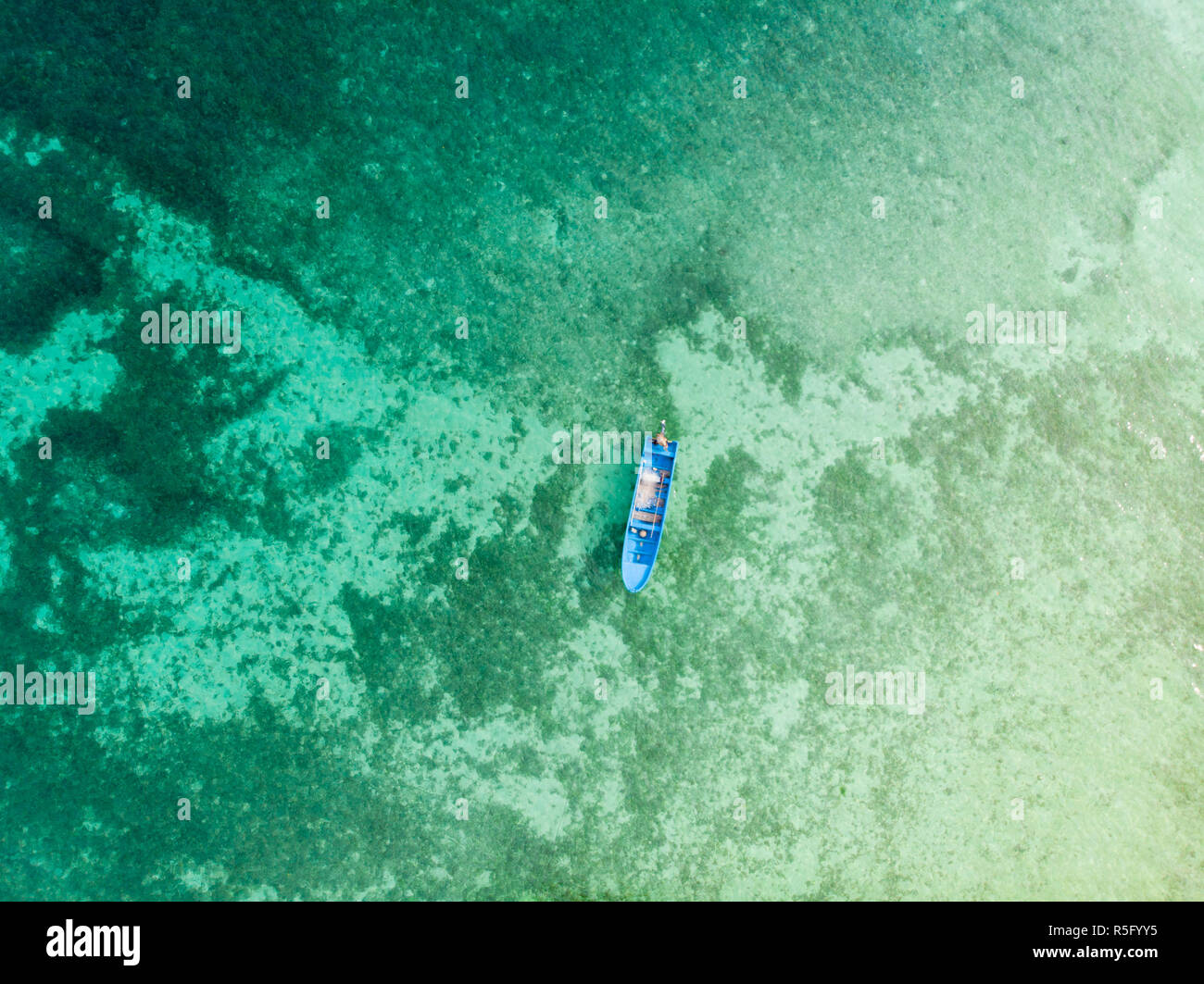 Aerial top down view boat canoe floating on turquoise coral reef ...