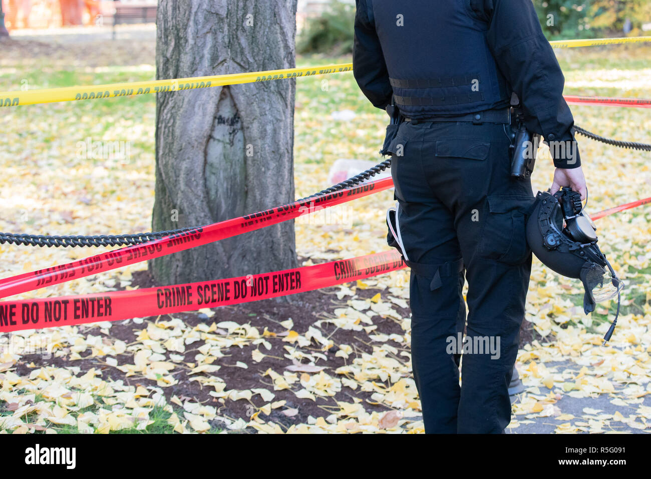 Police officer in the helmet standing by the crime scene closed by ...