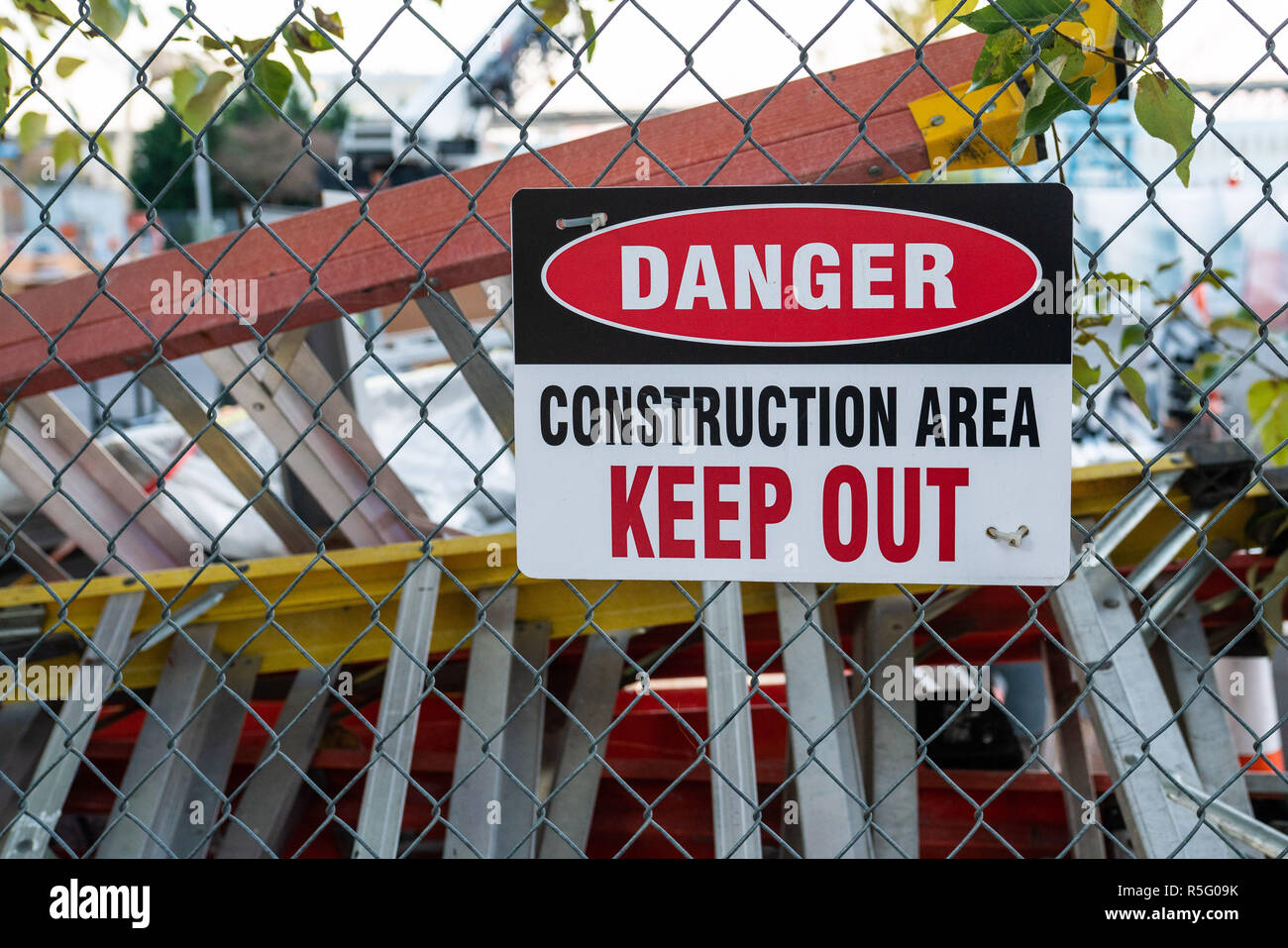 "Danger, construction area, keep out" sign on a chain link fence with ...