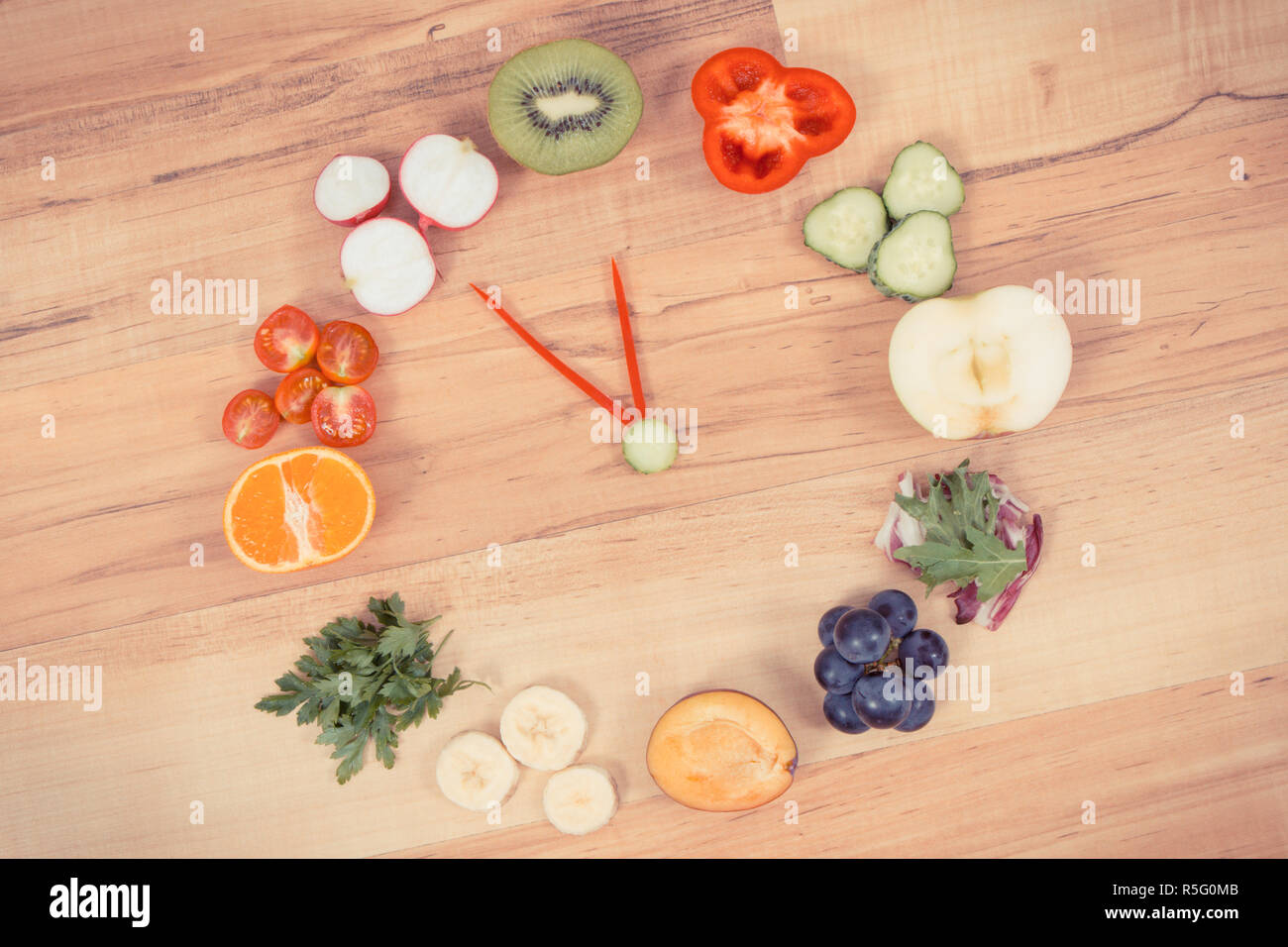Fresh ripe fruits and vegetables in shape of clock showing time for ...