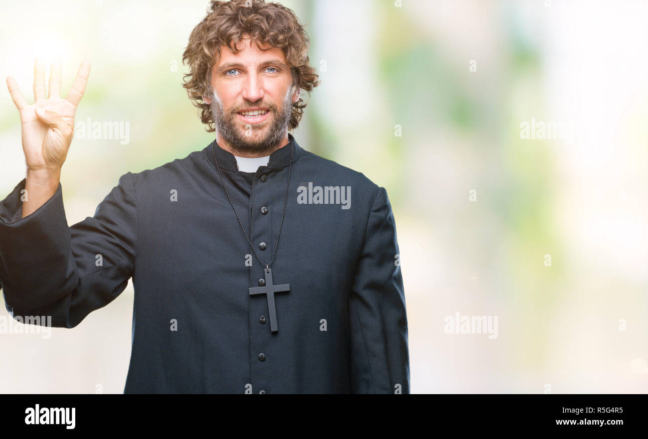 Handsome hispanic catholic priest man over isolated background showing ...