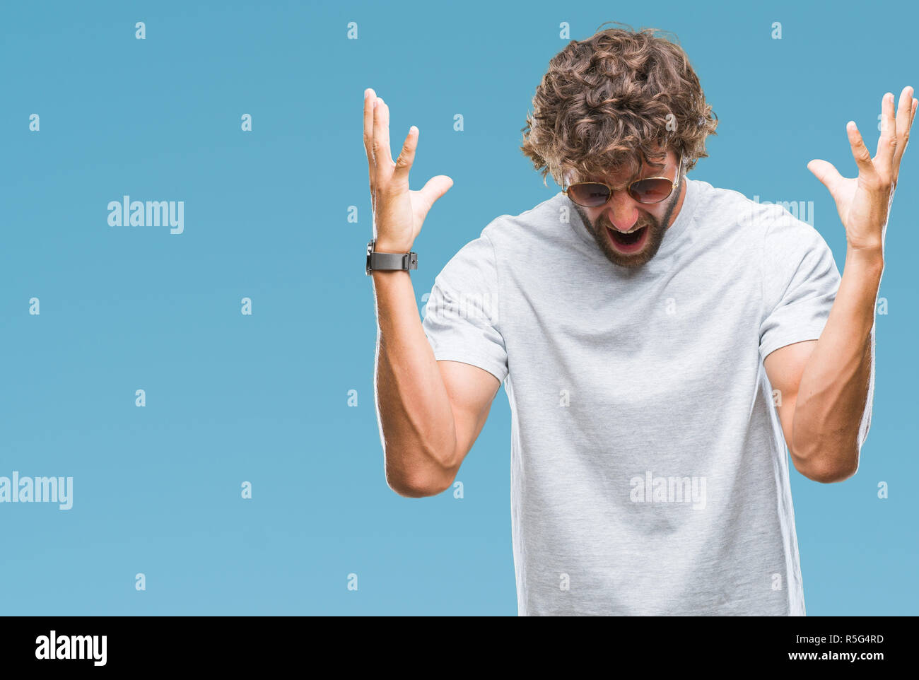 Handsome hispanic model man wearing sunglasses over isolated background ...