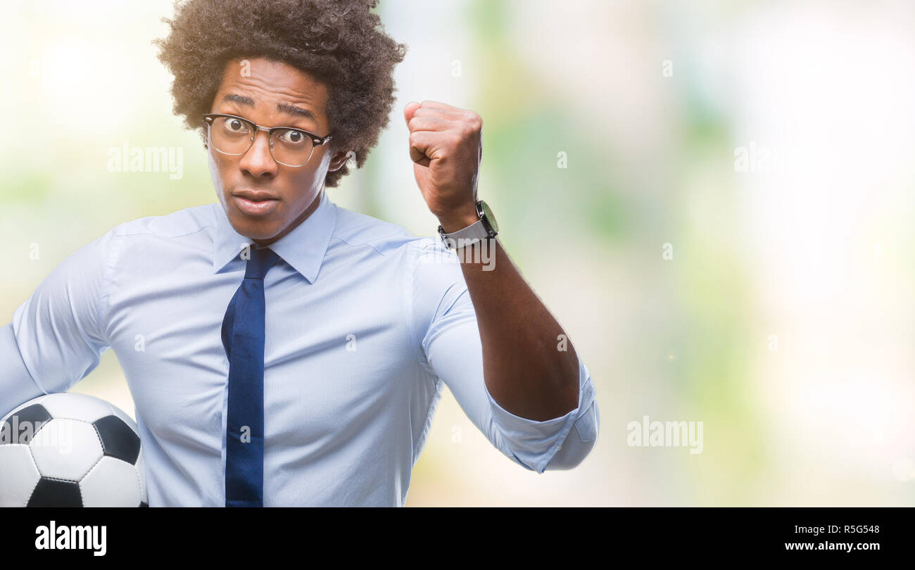 Afro american manager man holding soccer ball over isolated background ...