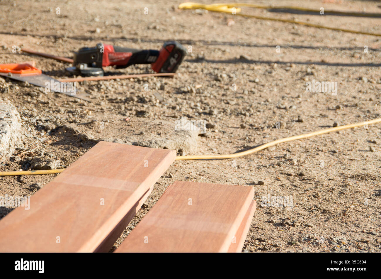 Tools on the ground in front of a stack of planks being used in home ...