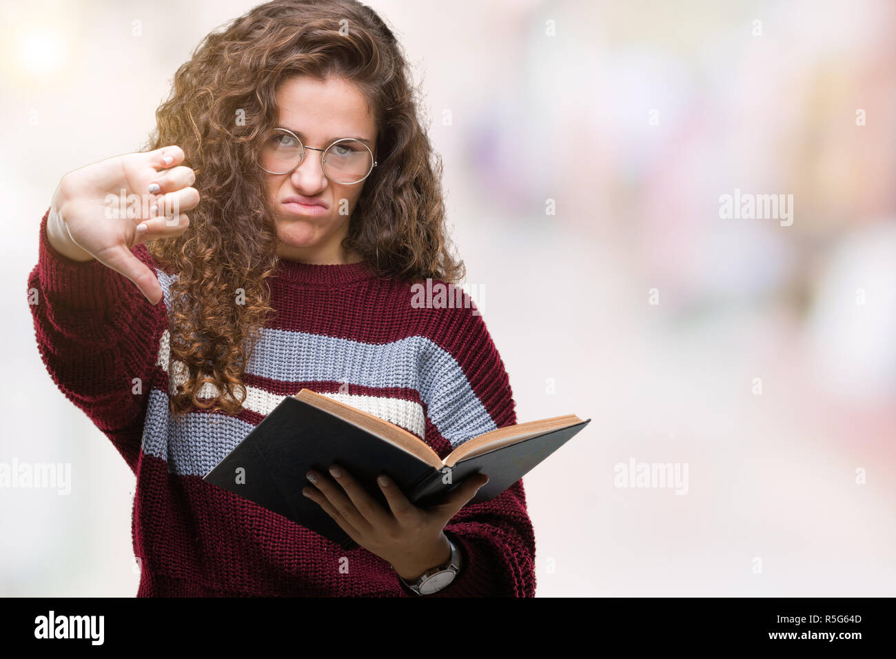Young brunette girl reading a book wearing glasses over isolated ...