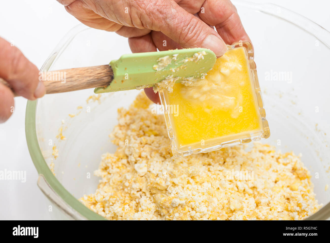 Adding melted butter to prepare sweet corn bread Stock Photo - Alamy