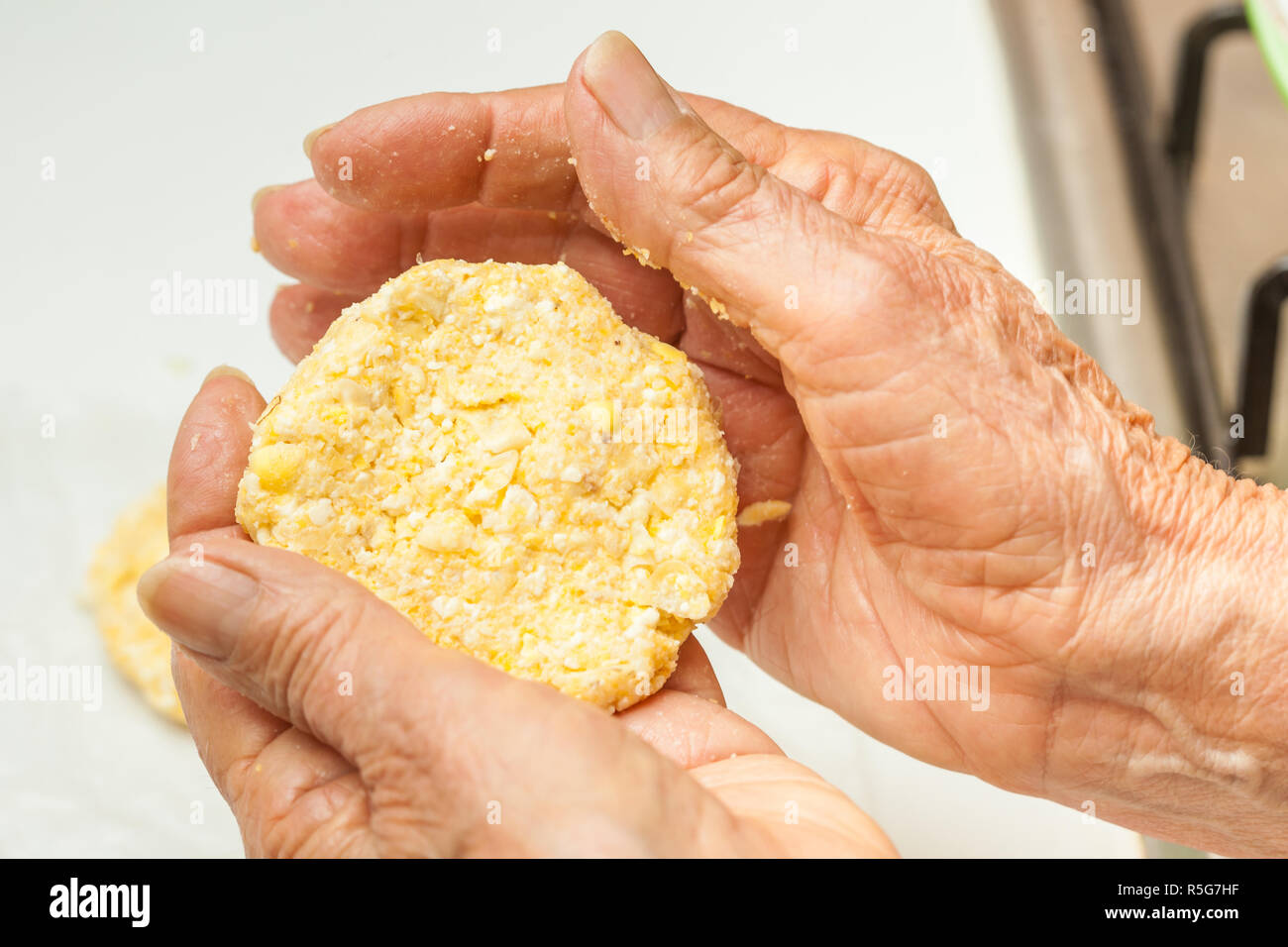 Flatten the dough balls to form the arepa typical shape Stock Photo - Alamy