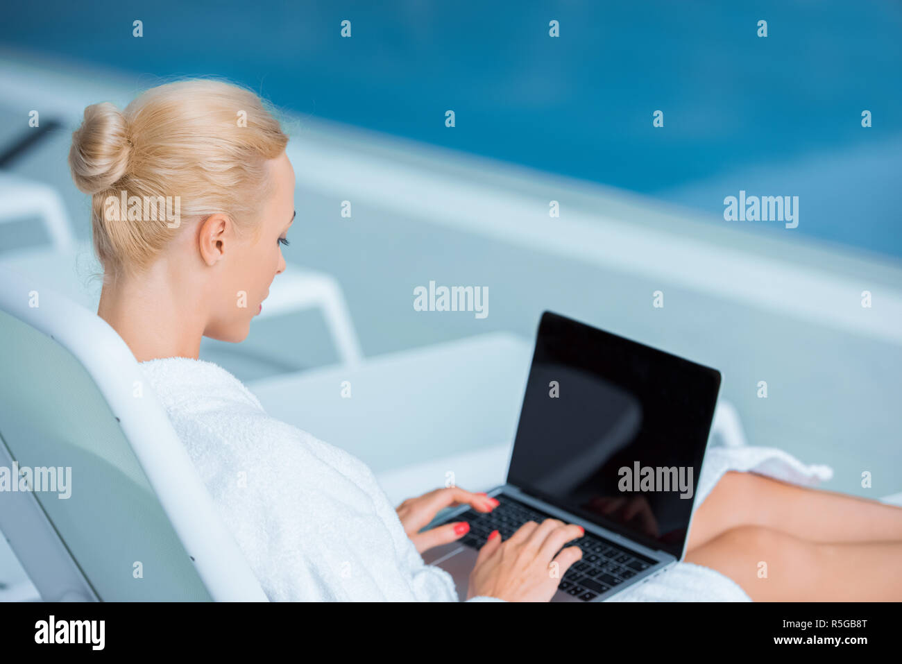 Woman using laptop swimming pool hi-res stock photography and images ...