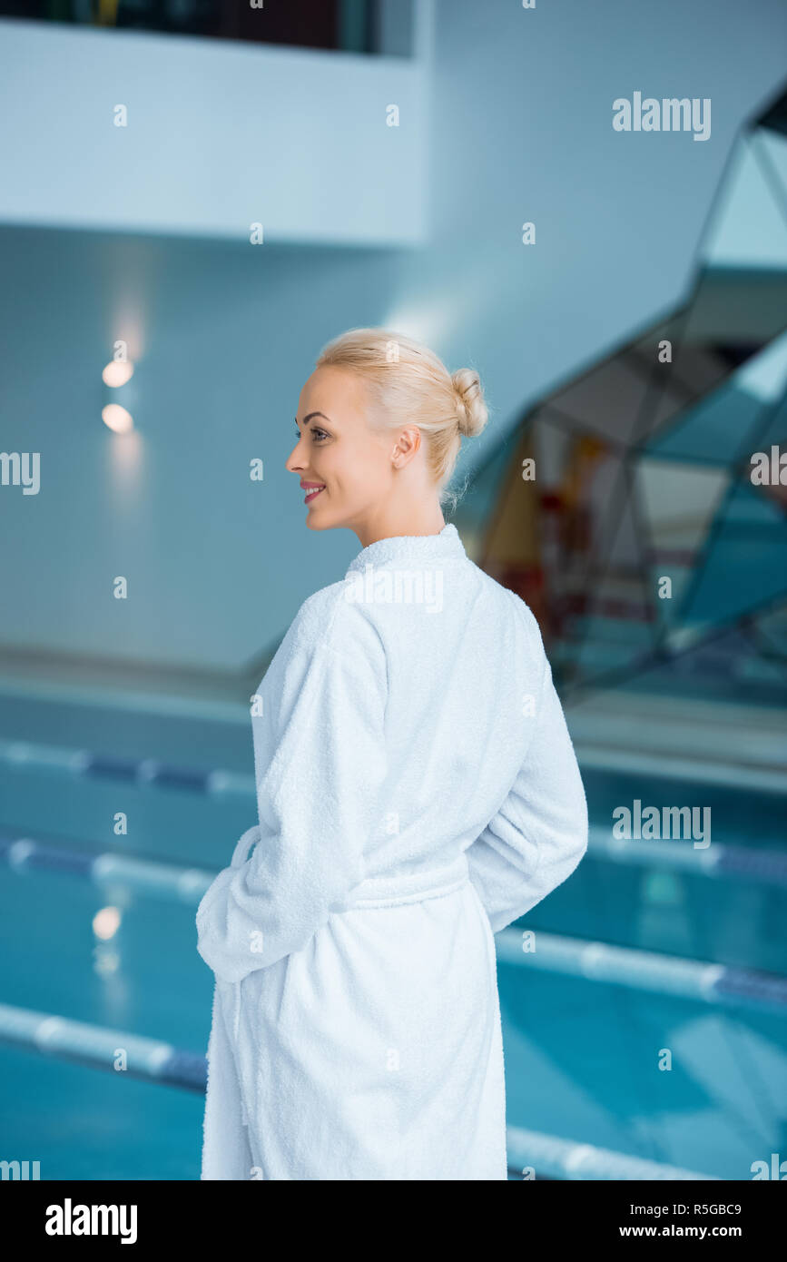 Beautiful woman standing in bathrobe near pool Stock Photo - Alamy