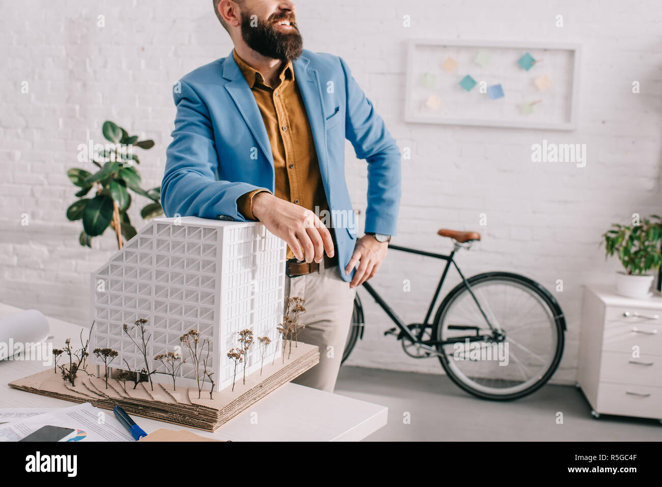 cropped view of happy adult male architect in formal wear standing near ...