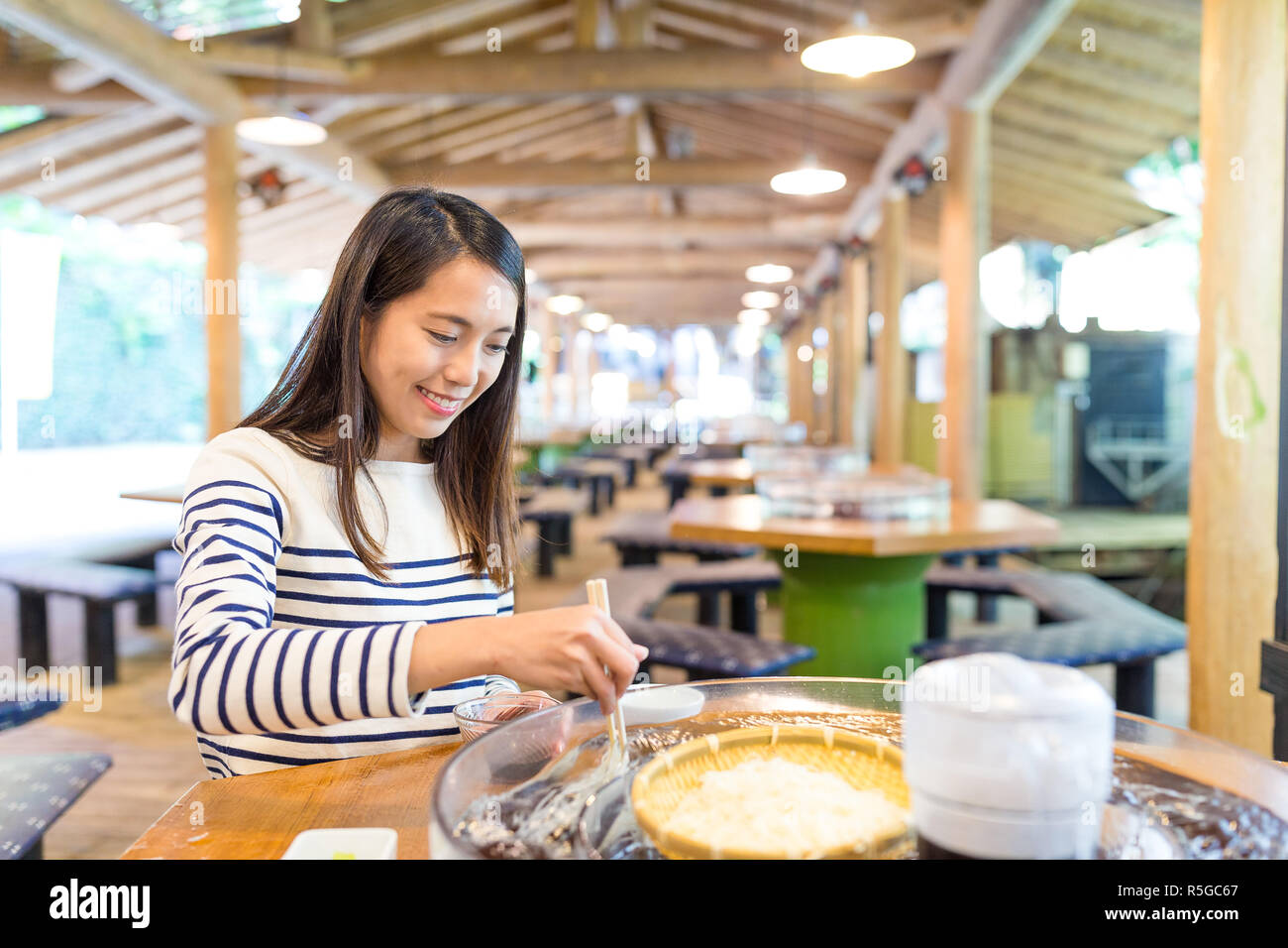 Woman enjoy water flow white noodles in restaurant Stock Photo - Alamy