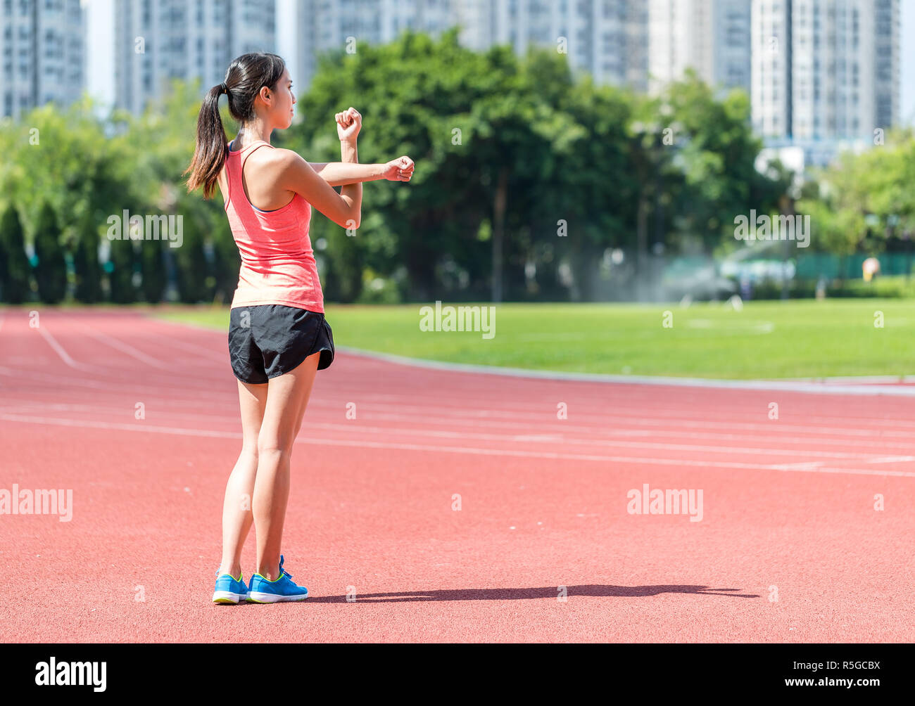 Back view of sport woman stretching hand Stock Photo - Alamy