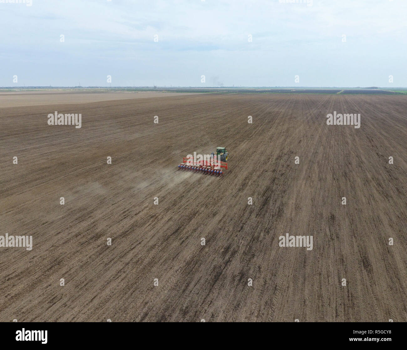 Sowing of corn. Tractor with a seeder on the field. Using a seeder for ...