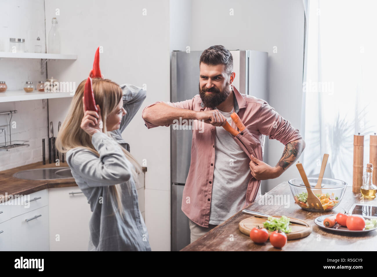 funny couple playing with vegetables at kitchen Stock Photo - Alamy