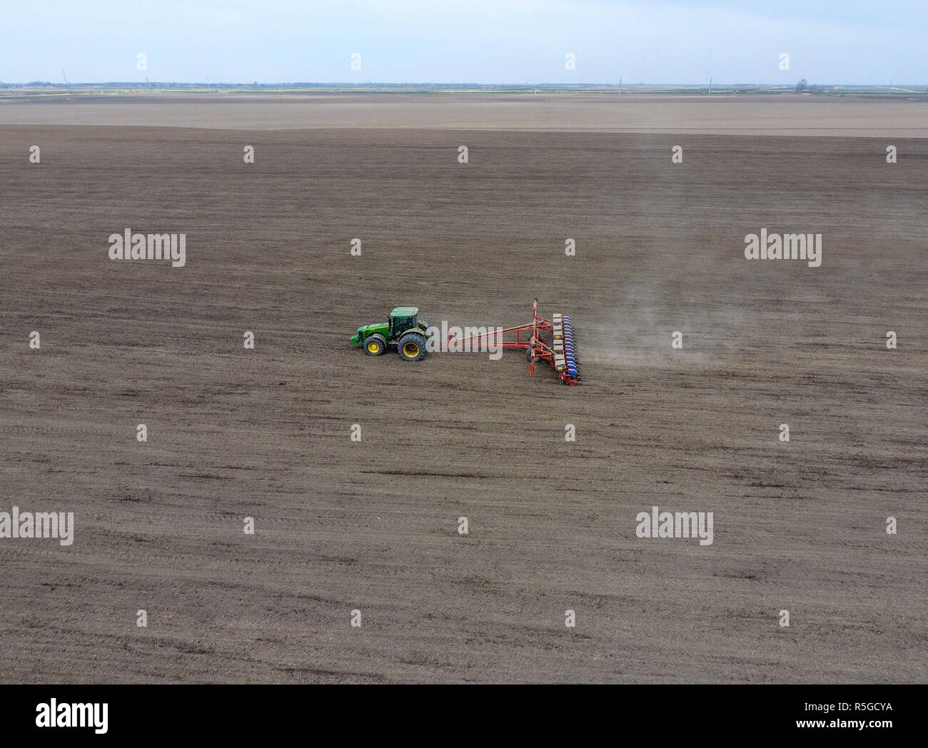 Sowing of corn. Tractor with a seeder on the field. Using a seeder for ...