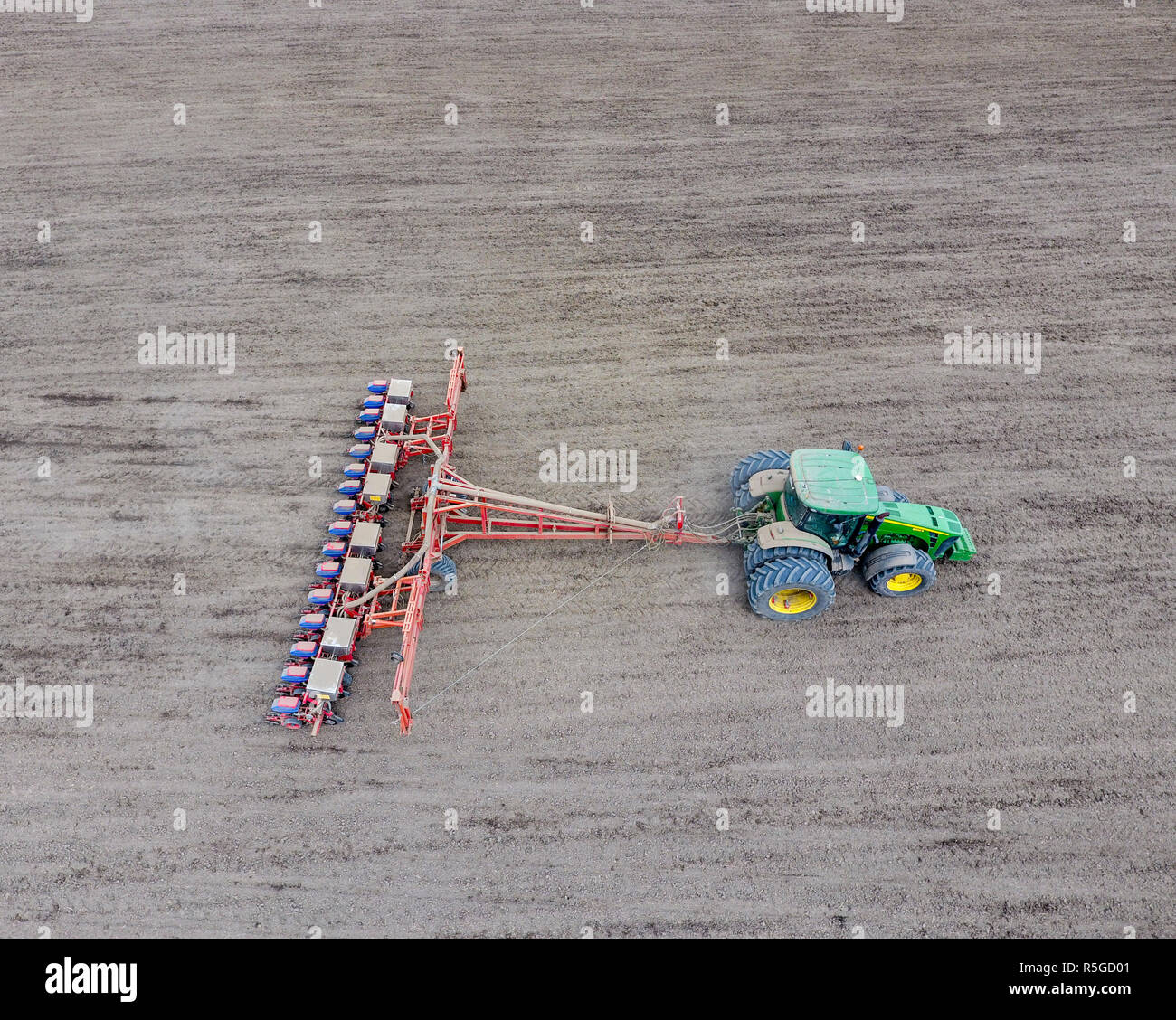 Sowing of corn. Tractor with a seeder on the field. Using a seeder for ...