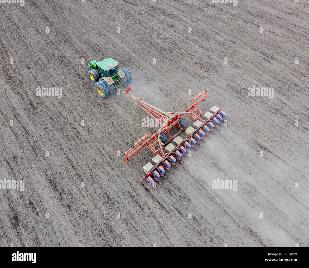 Sowing of corn. Tractor with a seeder on the field. Using a seeder for ...