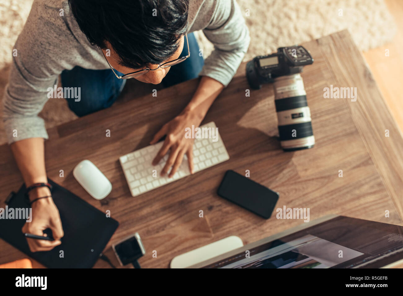 Overhead view of photographer editing photos at his studio ...