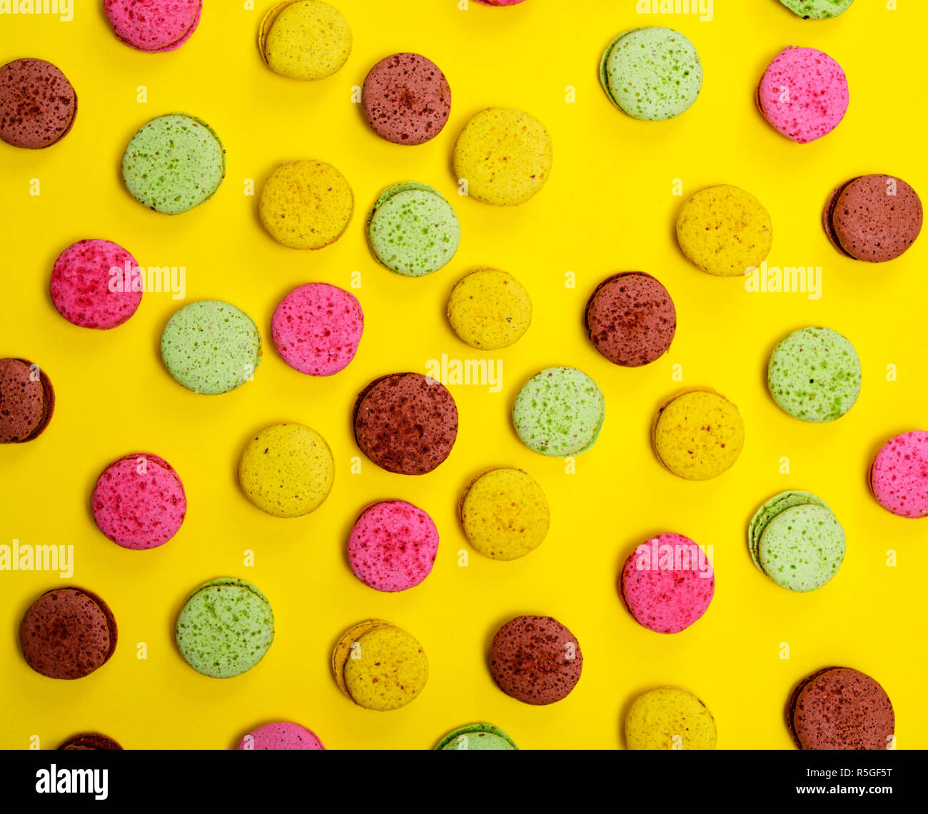 Colorful pastry macarons on a yellow background Stock Photo - Alamy