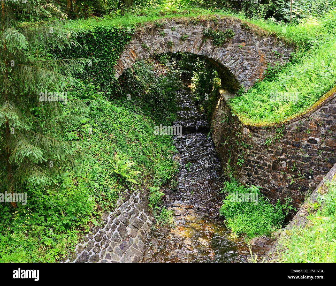 Stream under the bridge Stock Photo - Alamy