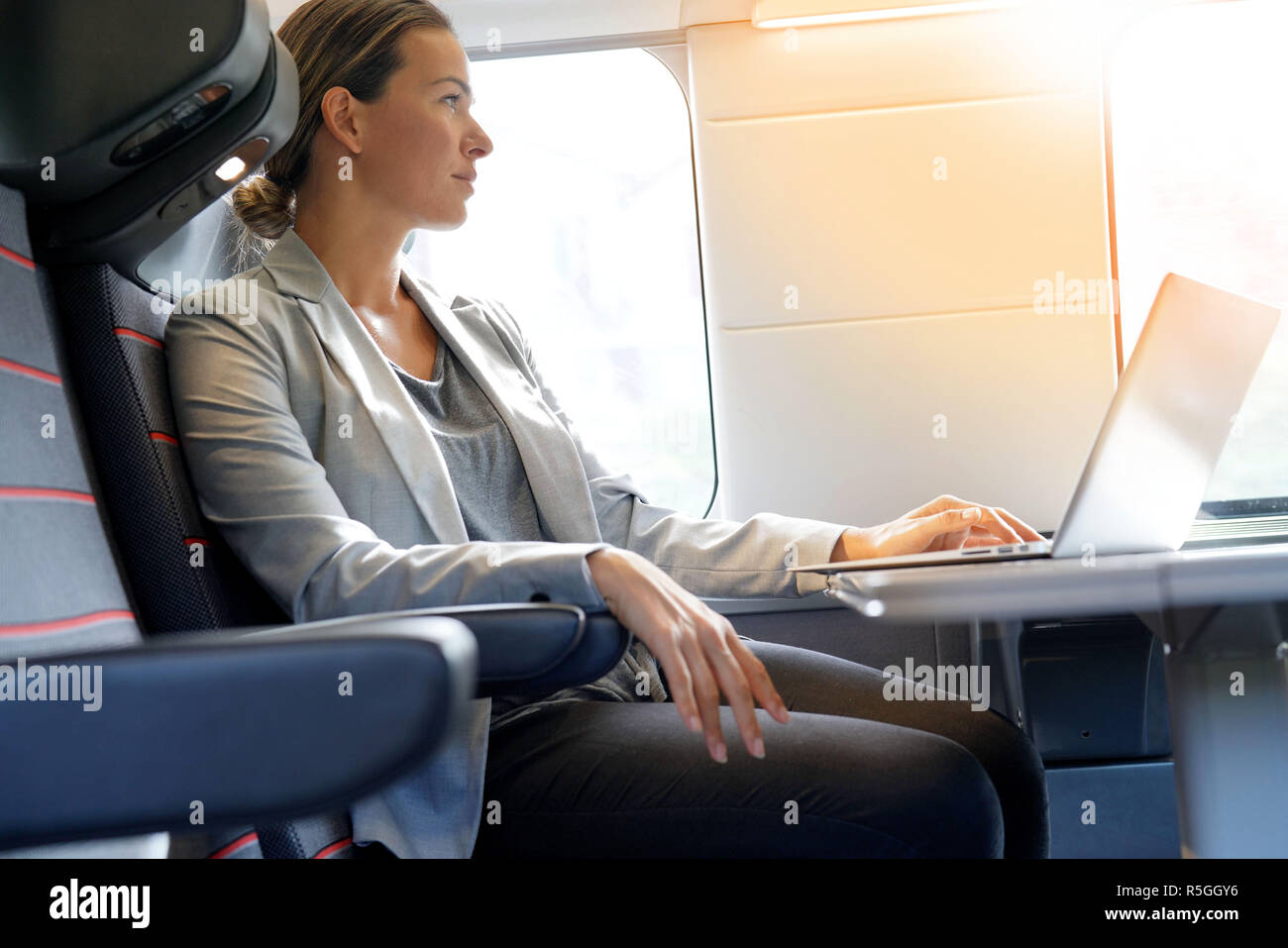 Businesswoman working in first class on a train Stock Photo - Alamy