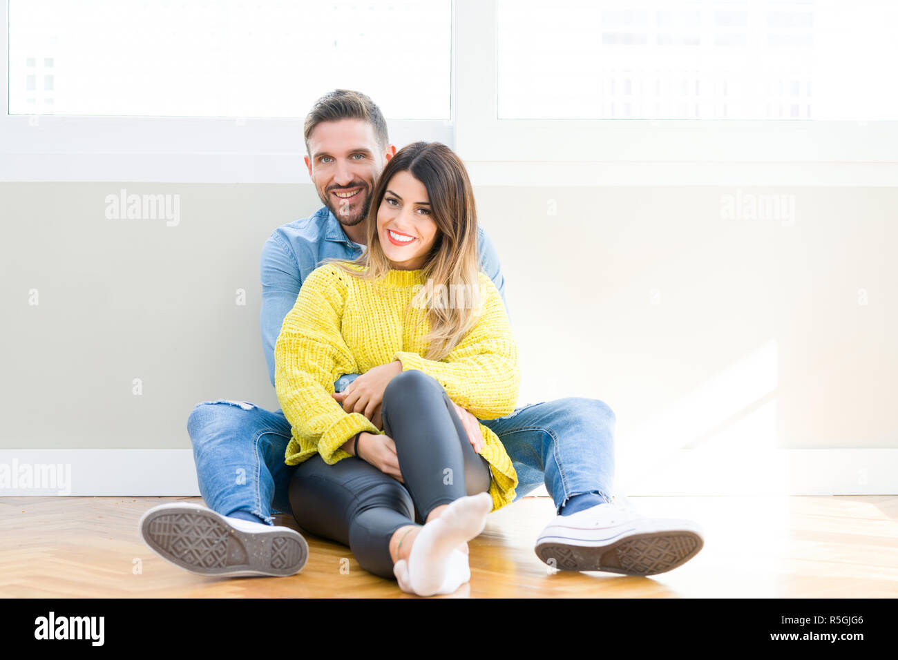 Beautiful young couple in love, kissing and hugging each other sitting ...