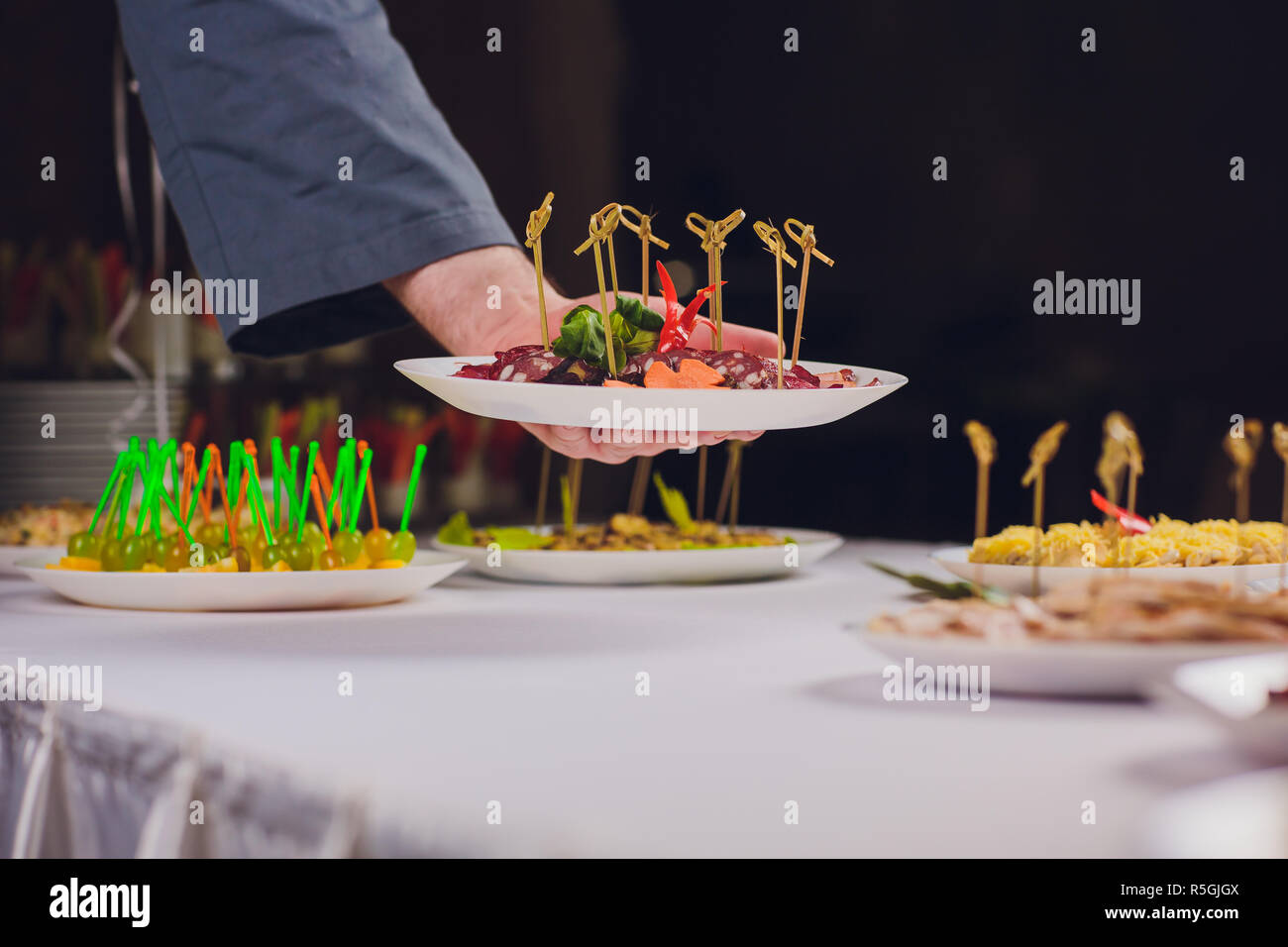 meat slicer hand catering service waiter cook Stock Photo - Alamy