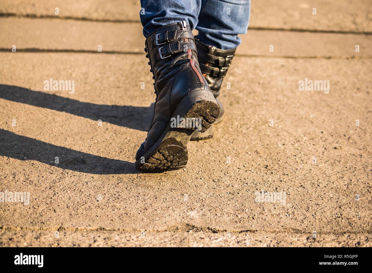 Female legs in high black boots walking down the street Stock Photo - Alamy